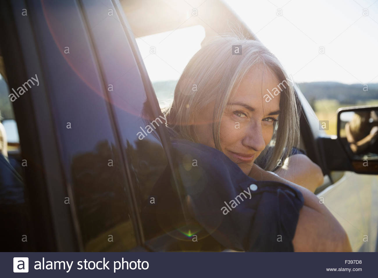 Portrait confident woman leaning out car window Stock Photo - Alamy