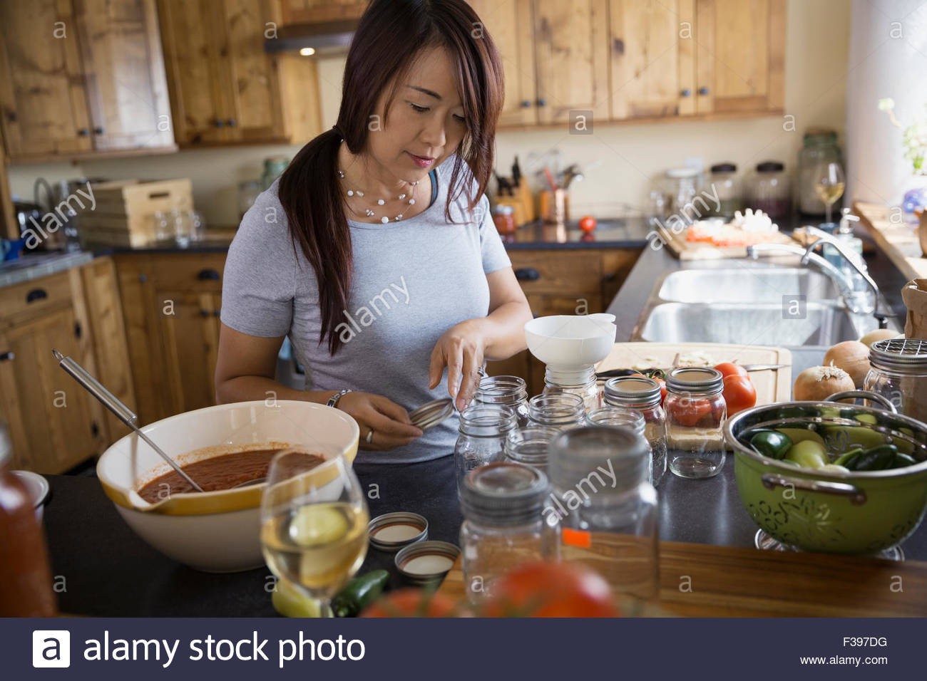 Woman canning tomato sauce in kitchen Stock Photo - Alamy