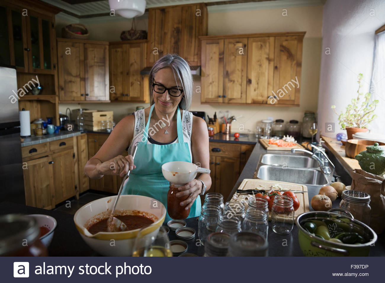 Woman canning tomato sauce in kitchen Stock Photo - Alamy