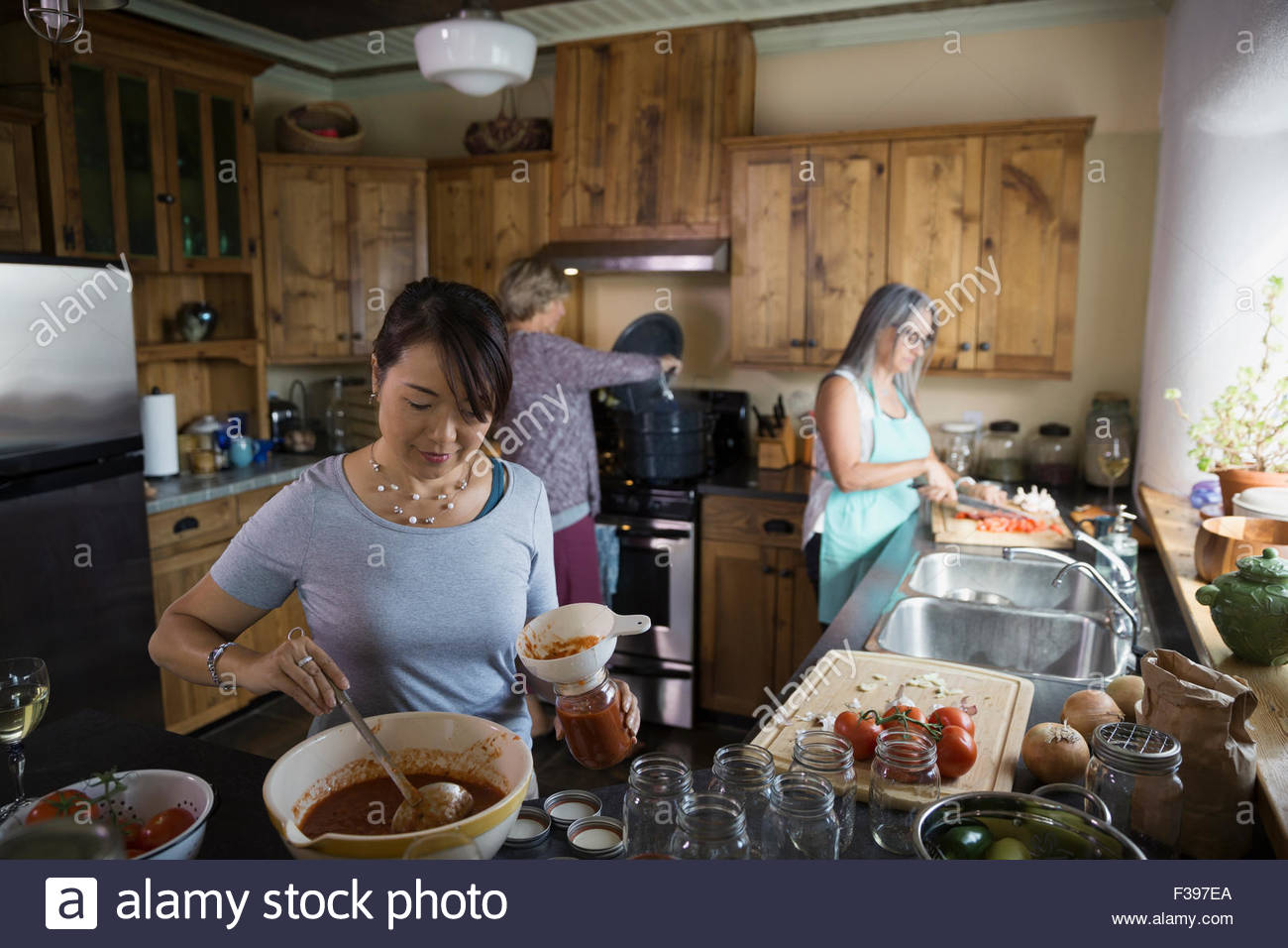 Women canning tomato sauce in kitchen Stock Photo - Alamy
