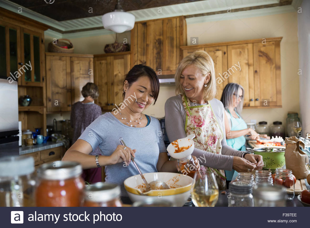 Smiling women canning tomato sauce in kitchen Stock Photo - Alamy