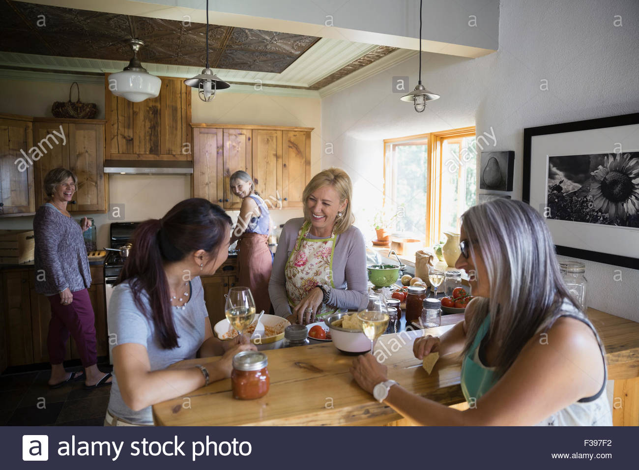 Women drinking wine and cooking in kitchen Stock Photo - Alamy