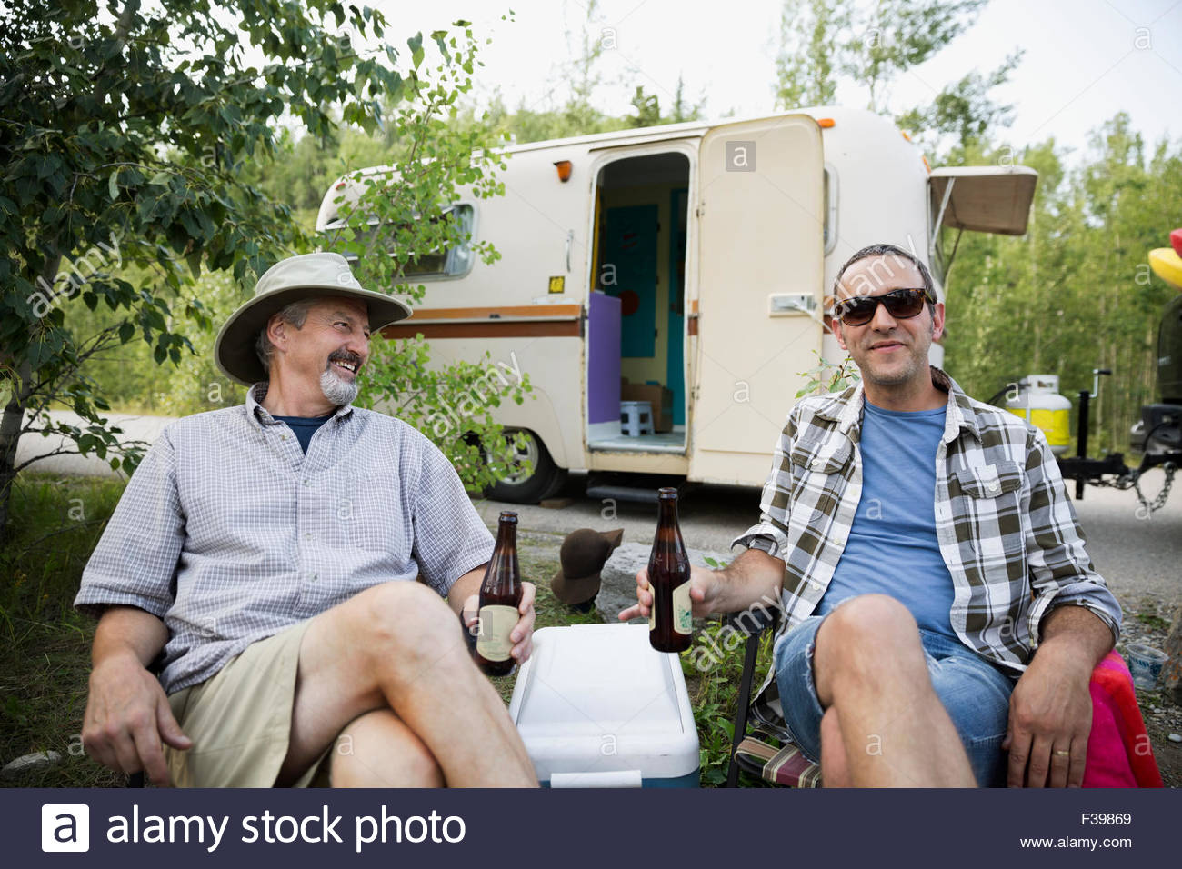 Father and son drinking beer campsite outside camper Stock Photo - Alamy