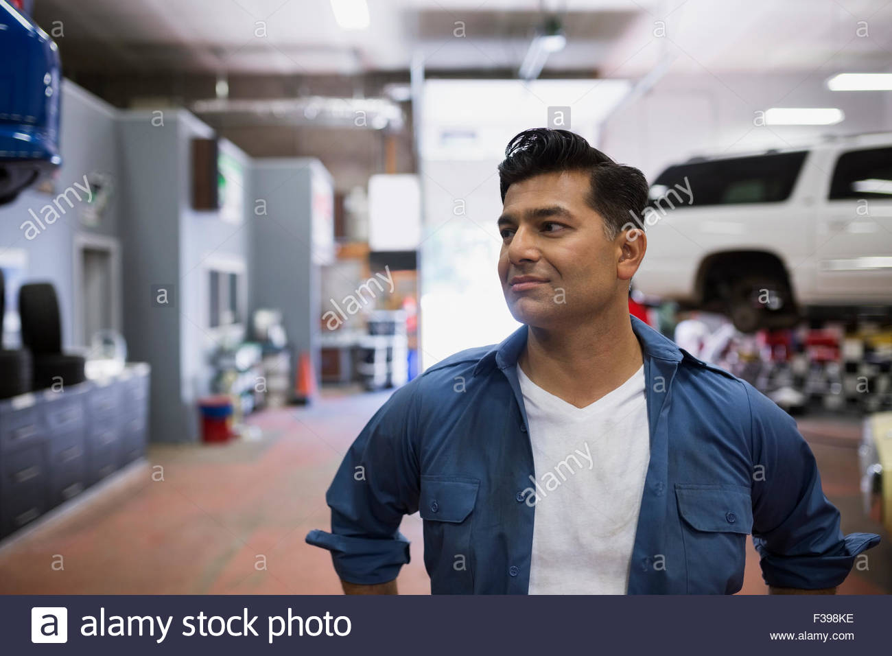 Confident mechanic looking away in auto repair shop Stock Photo - Alamy