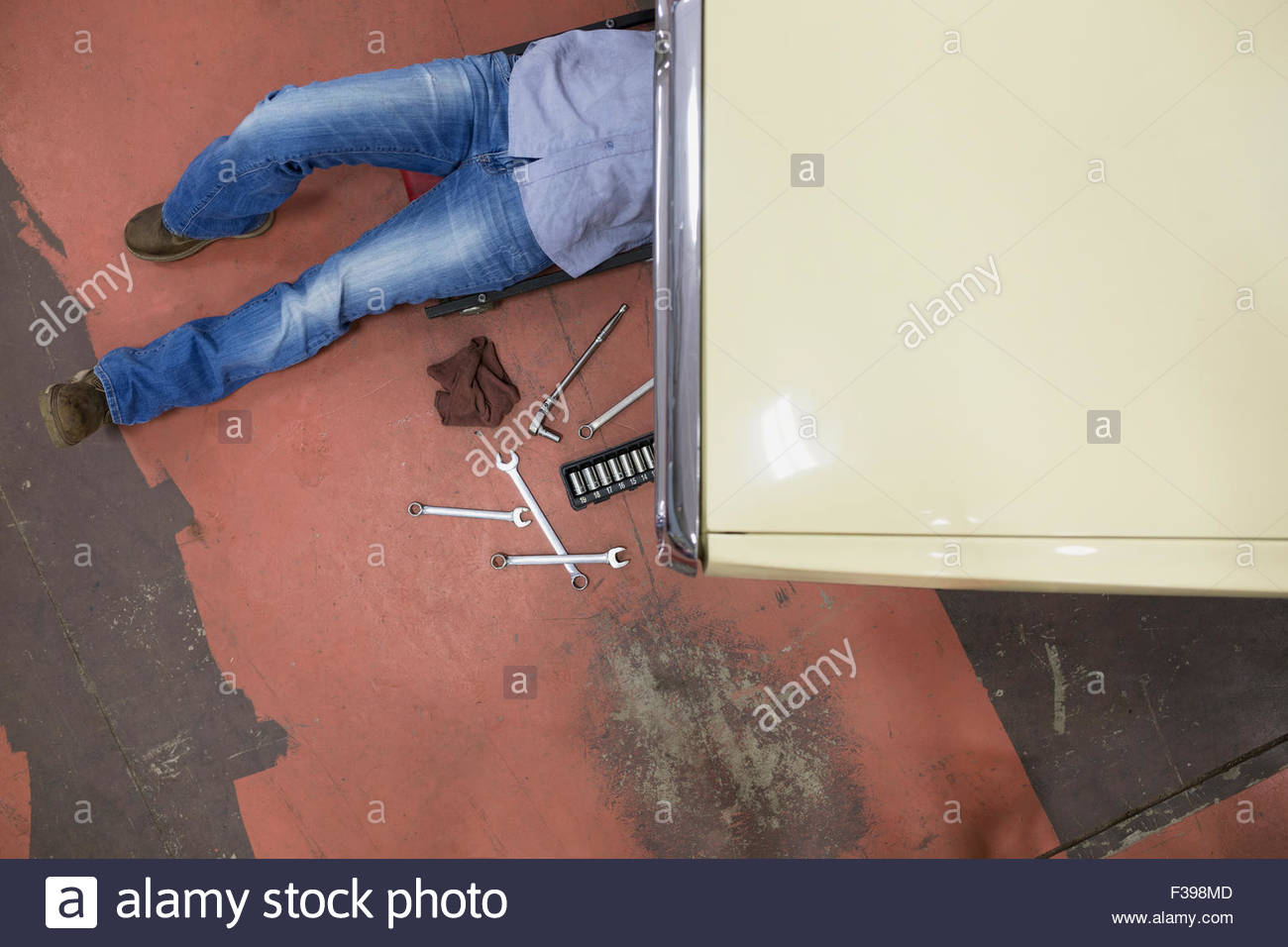 Overhead view female mechanic underneath car Stock Photo - Alamy