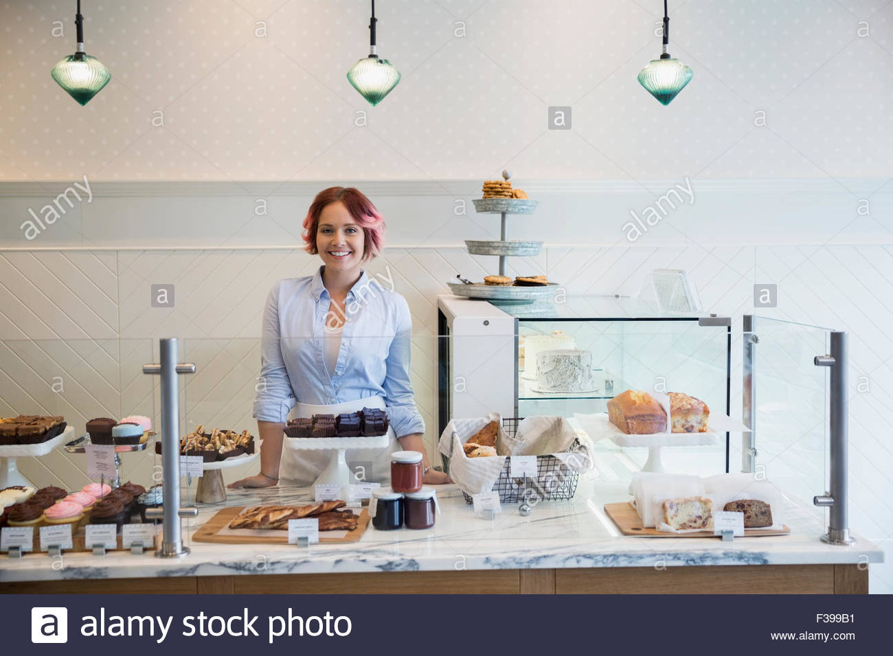 Woman smiling behind bakery counter High Resolution Stock Photography ...