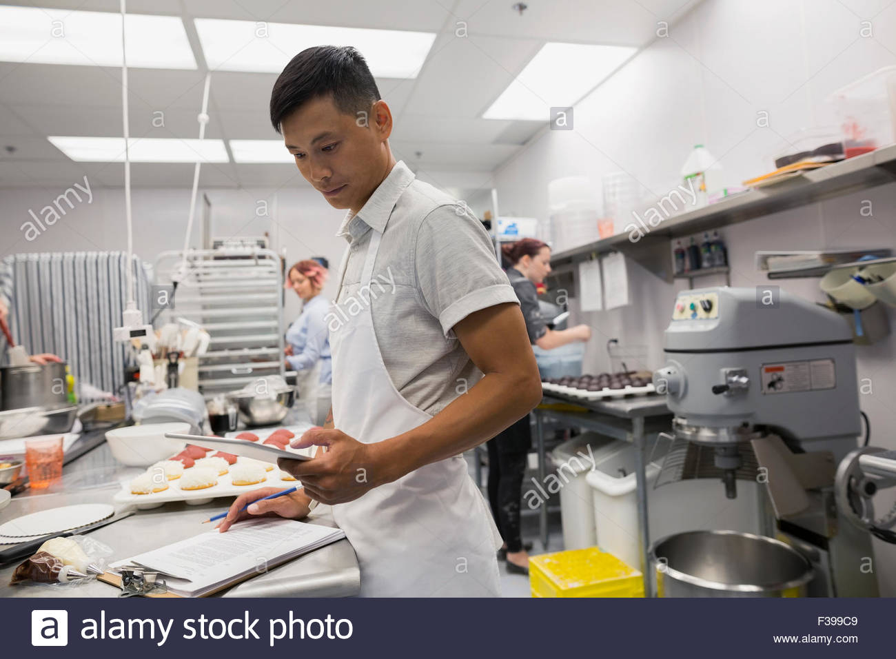 Pastry chef with digital tablet in commercial kitchen Stock Photo - Alamy