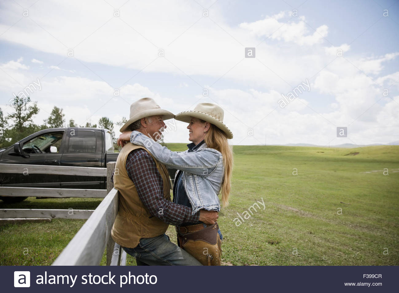 Affectionate rancher couple hugging at rural fence Stock Photo - Alamy