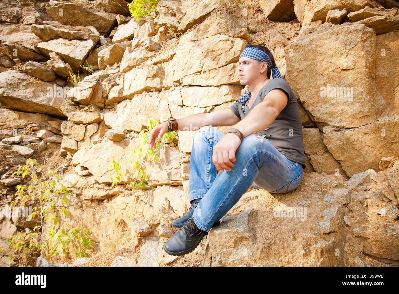 Man resting in the mountains sitting on the rock Stock Photo - Alamy