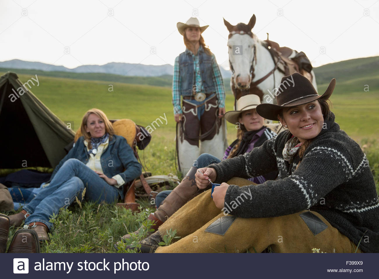 Female ranchers relaxing at campsite in remote field Stock Photo - Alamy