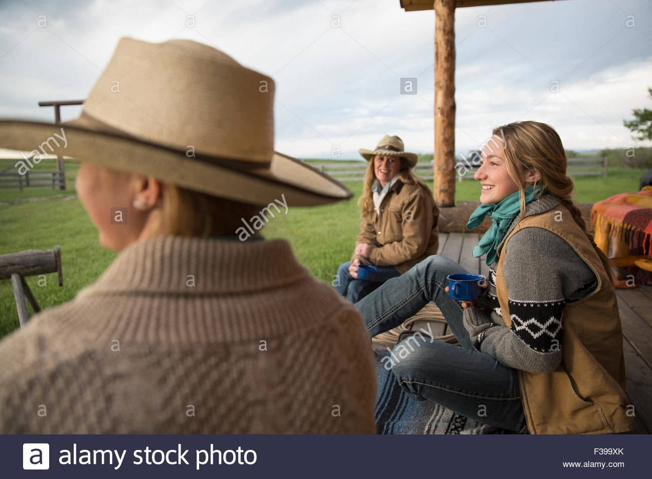 Female ranchers drinking coffee on porch Stock Photo - Alamy