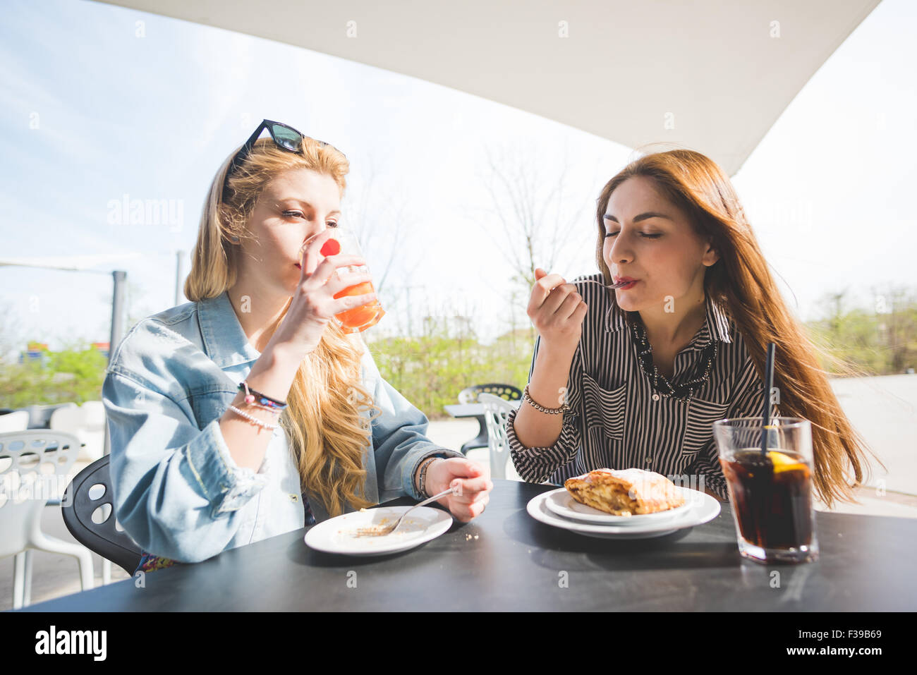 Two young handsome caucasian and eastern girls having an happy hour in ...