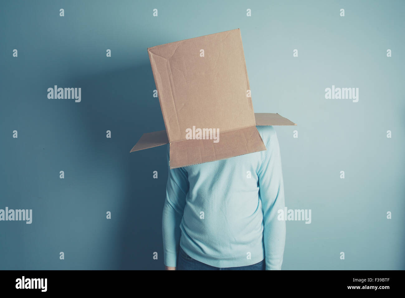 A man is standing with a cardboard box over his head Stock Photo - Alamy