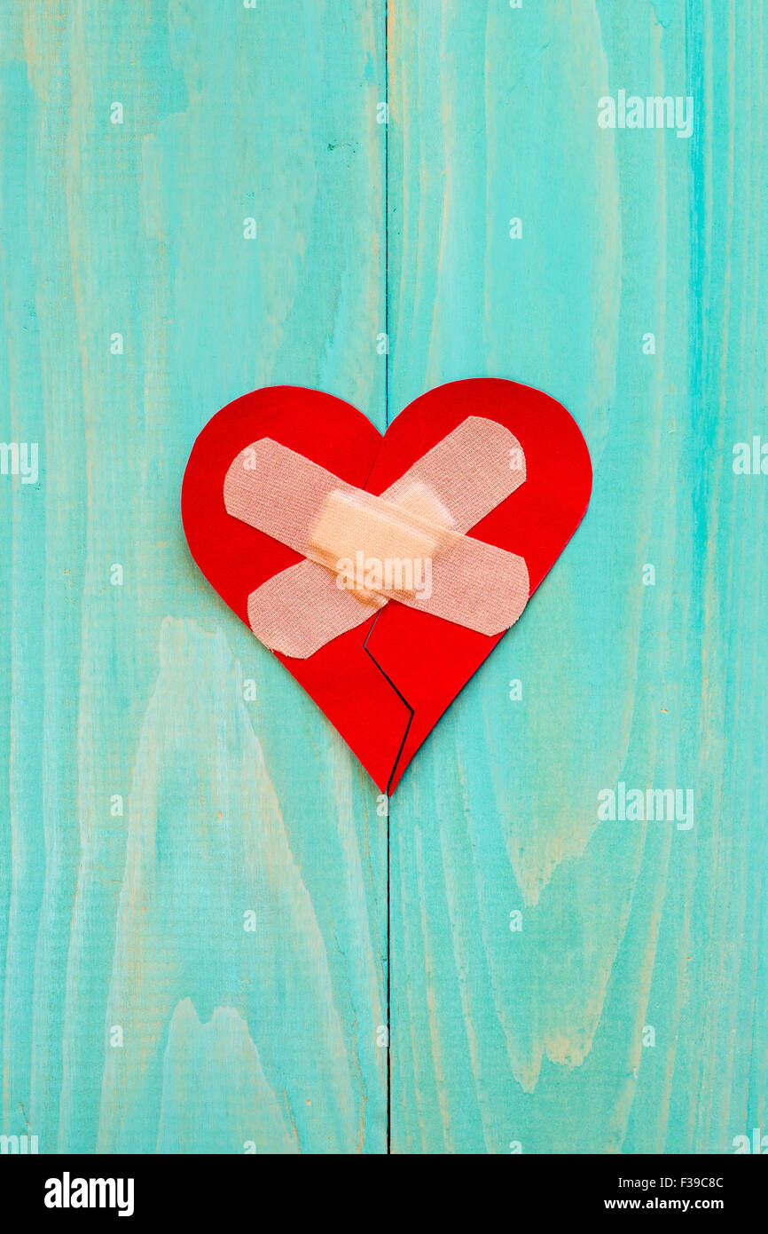 Plaster and paper broken heart on wooden background with copy-space ...