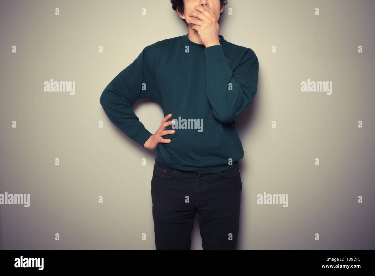 A young man is standing and looking nervous Stock Photo - Alamy