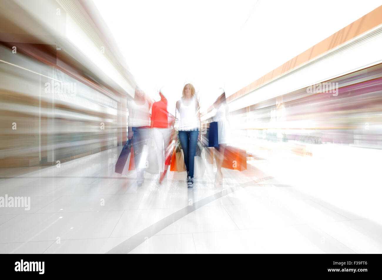 Women walking fast in shopping mall with bags Stock Photo - Alamy