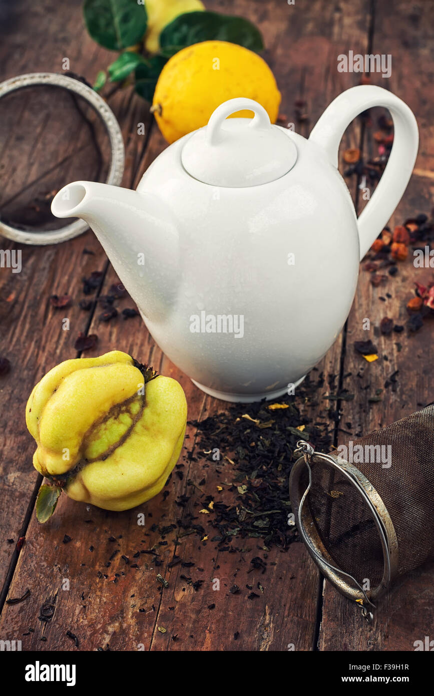 White teapot on background of quince fruit and spilled tea Stock Photo ...