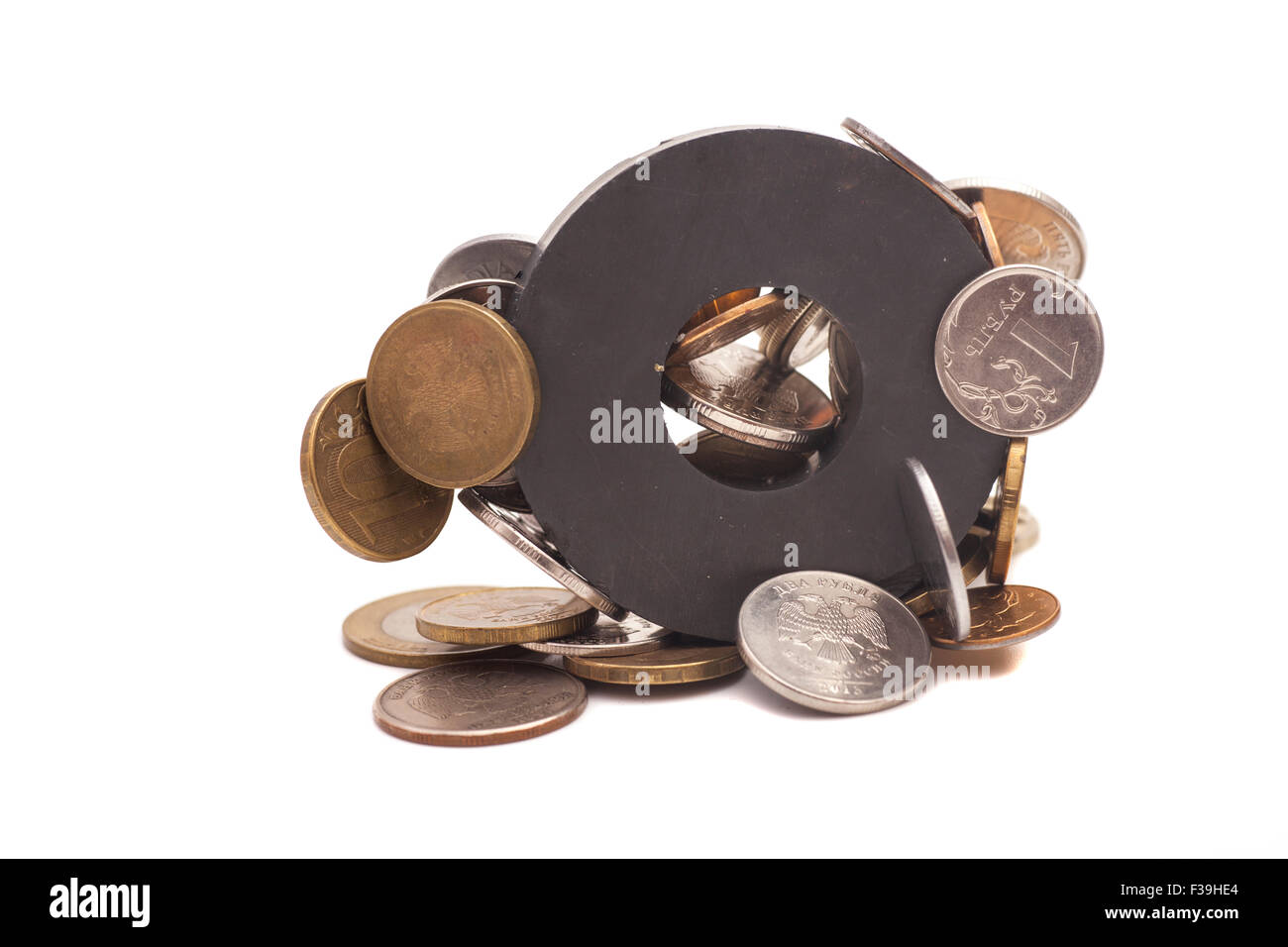 Coins attracted by magnet isolated on white background Stock Photo - Alamy
