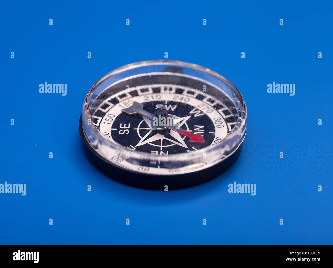 Compass on blue background Stock Photo - Alamy