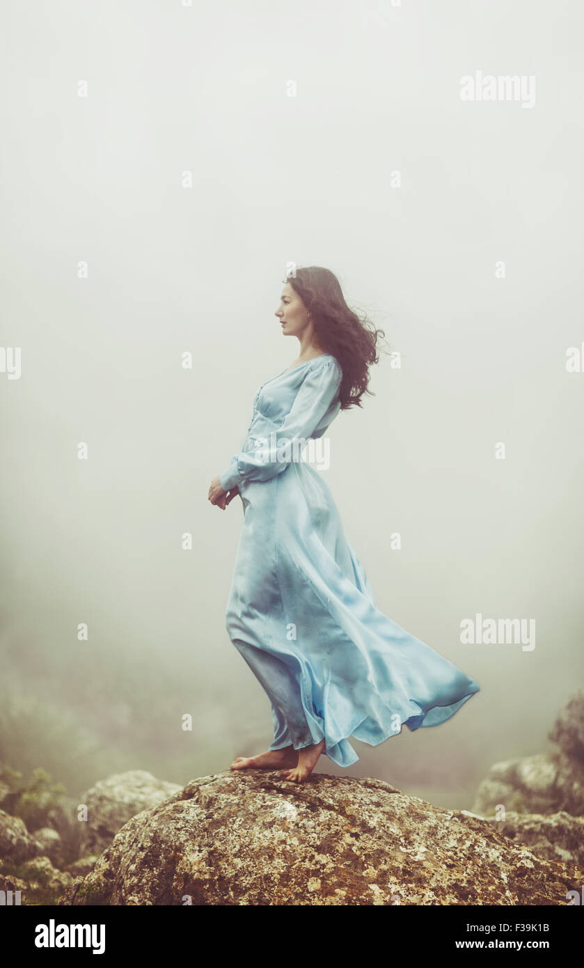 Portrait of a mid adult woman standing on rocks in the mist Stock Photo ...