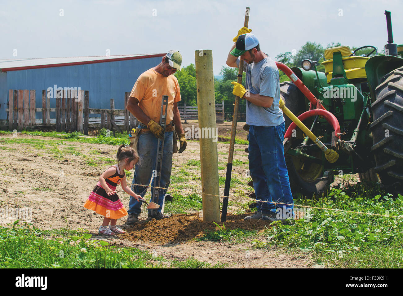 Girl helping two workmen on farm Stock Photo - Alamy