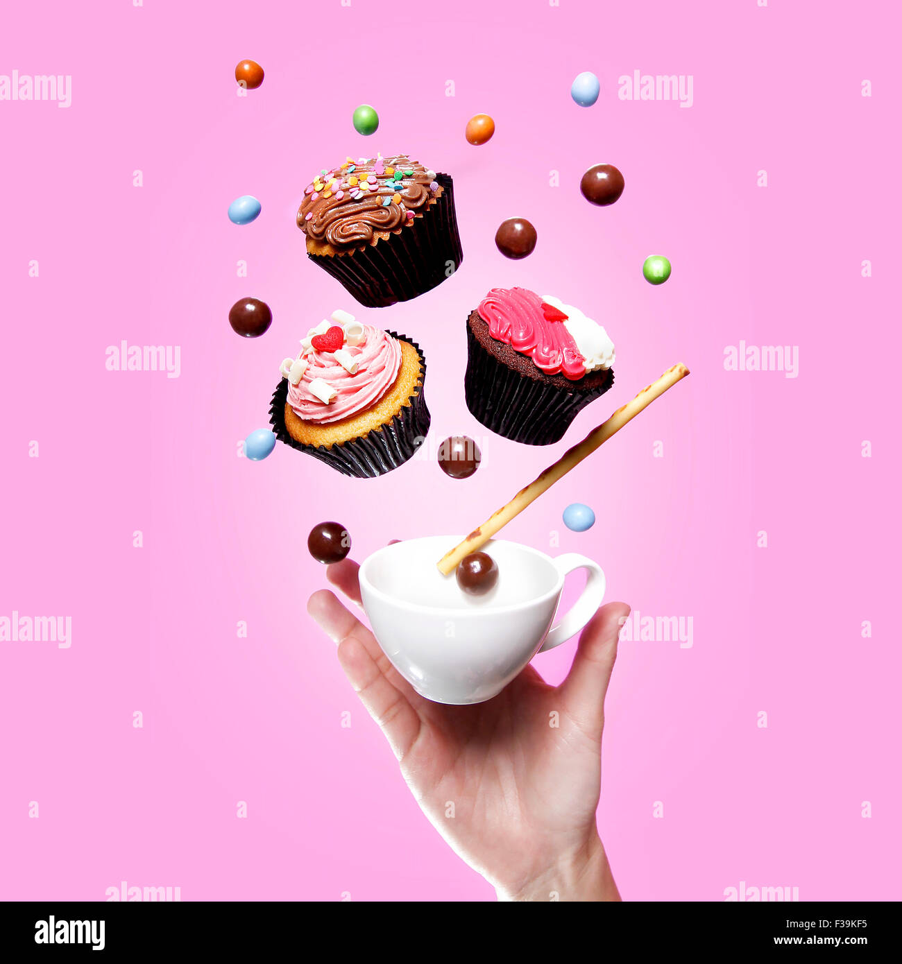 Flying Cupcakes, teacup, sweets and a hand Stock Photo - Alamy