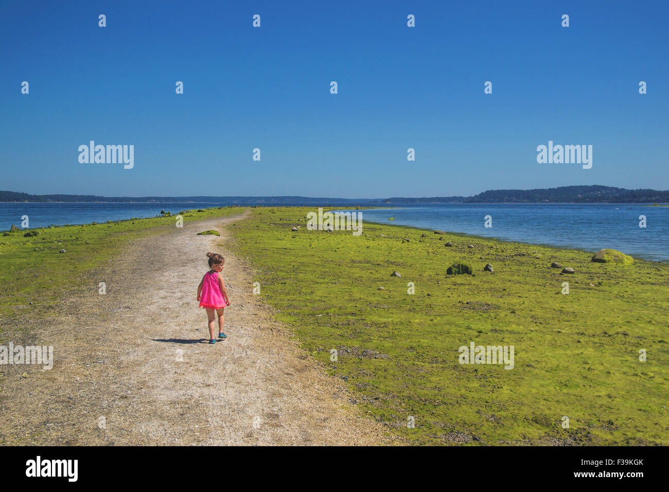 Girl walking down path Stock Photo - Alamy