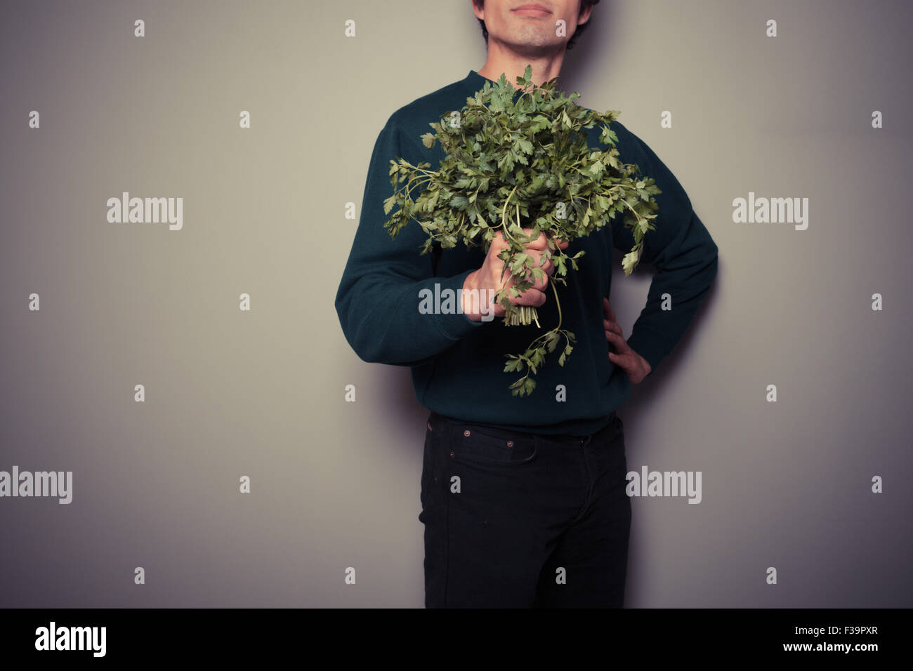 A happy young man is holding a big bunch of fresh parsley Stock Photo ...