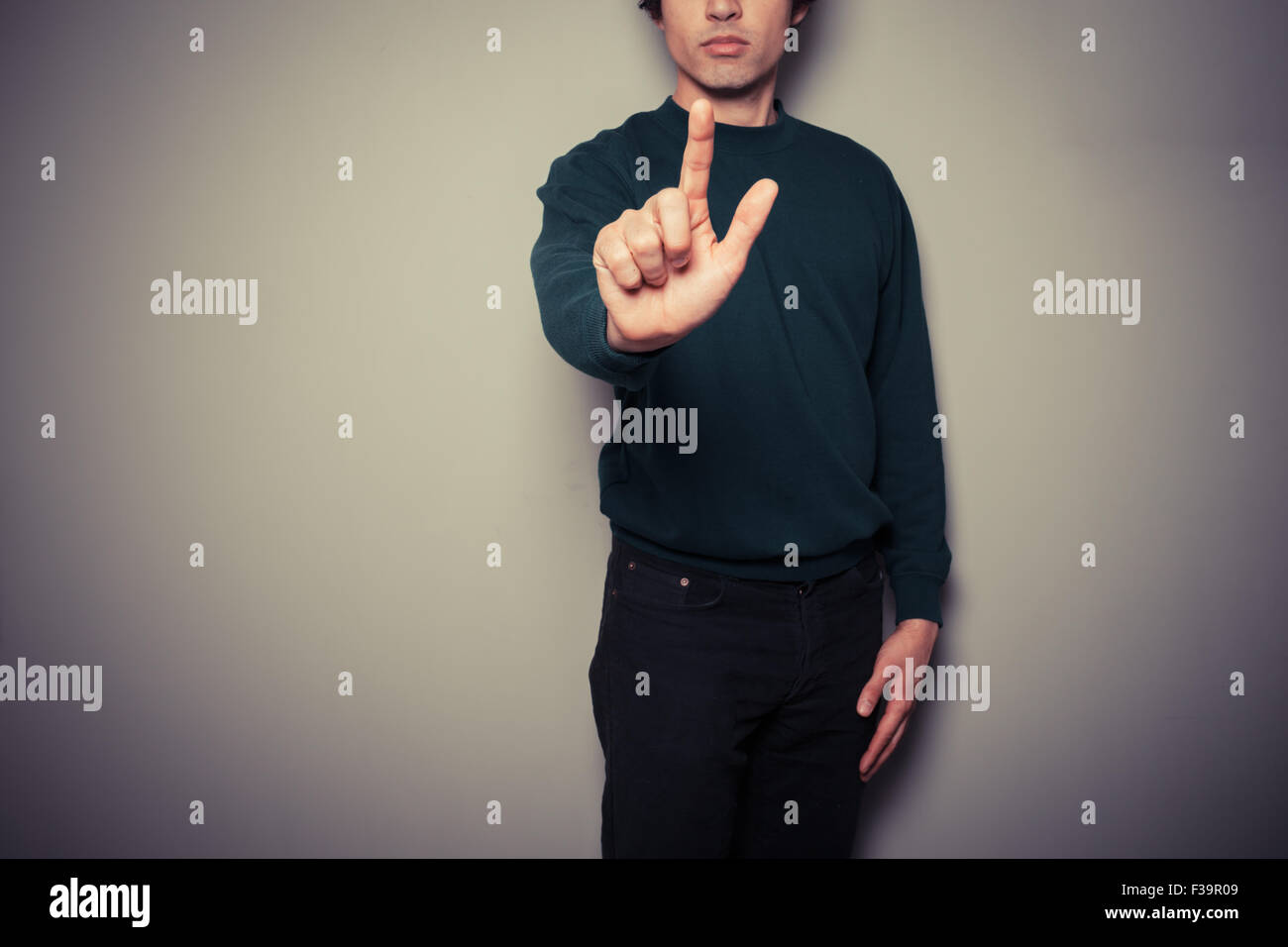 A young man is pointing or pushing a button with his finger Stock Photo ...