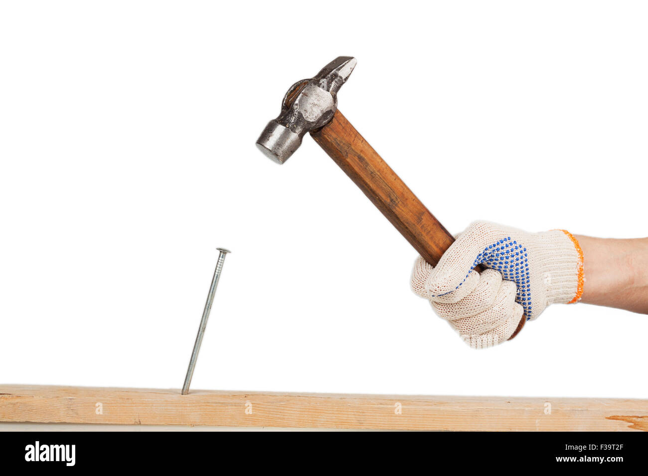 male hand in working glove hits the nail into a wooden board on the ...