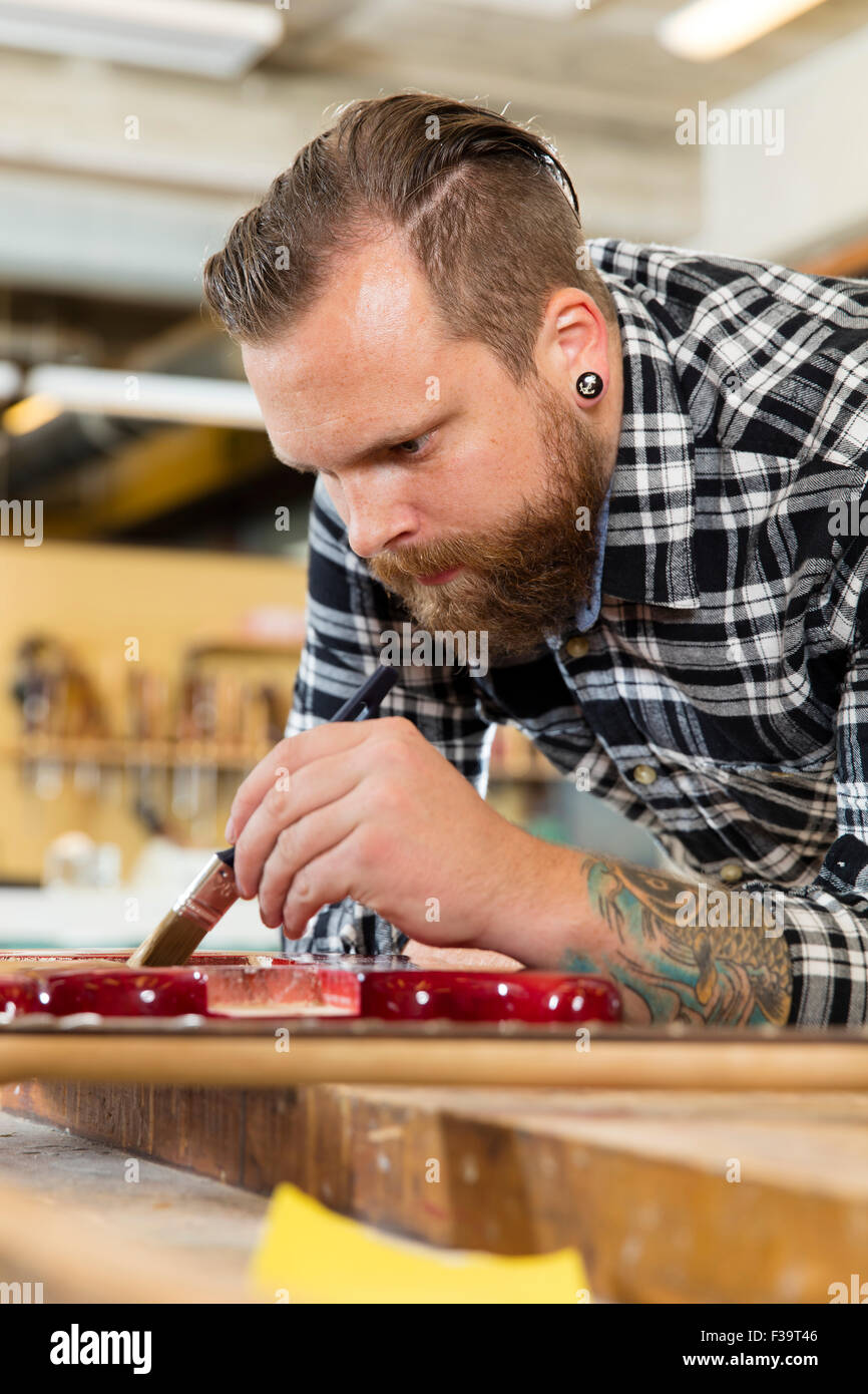 Man working at workshop with musical instruments Stock Photo - Alamy