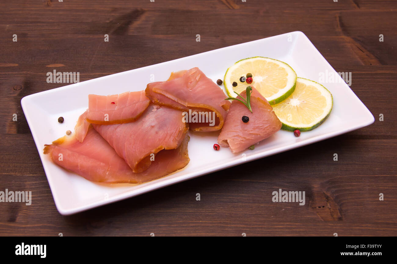 Smoked tuna on tray on wooden table Stock Photo - Alamy