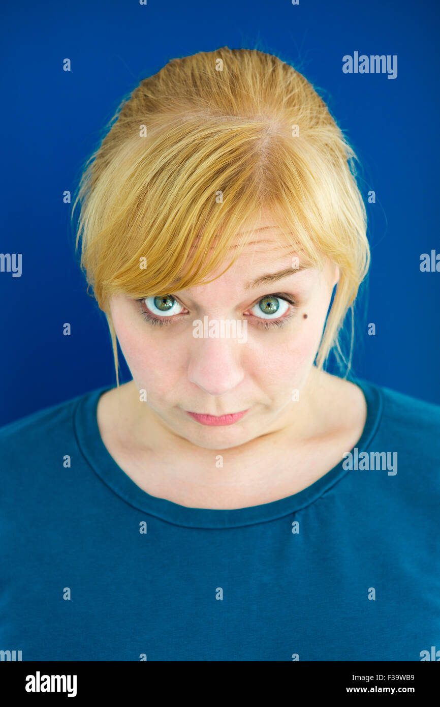 portrait of young blond woman looking questioningly with blue ...