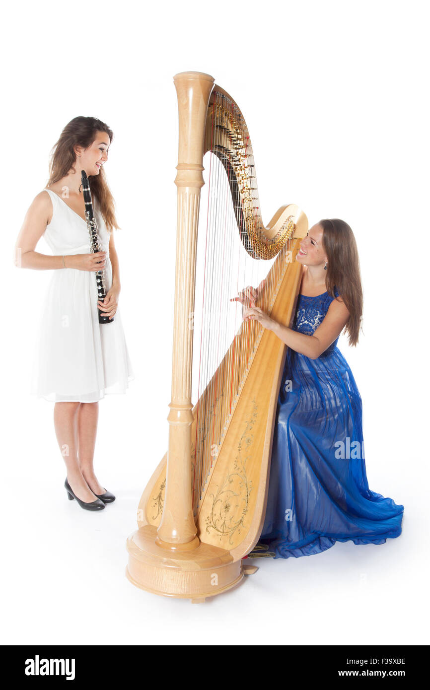 two young caucasian female musicians in studio with harp and clarinet ...