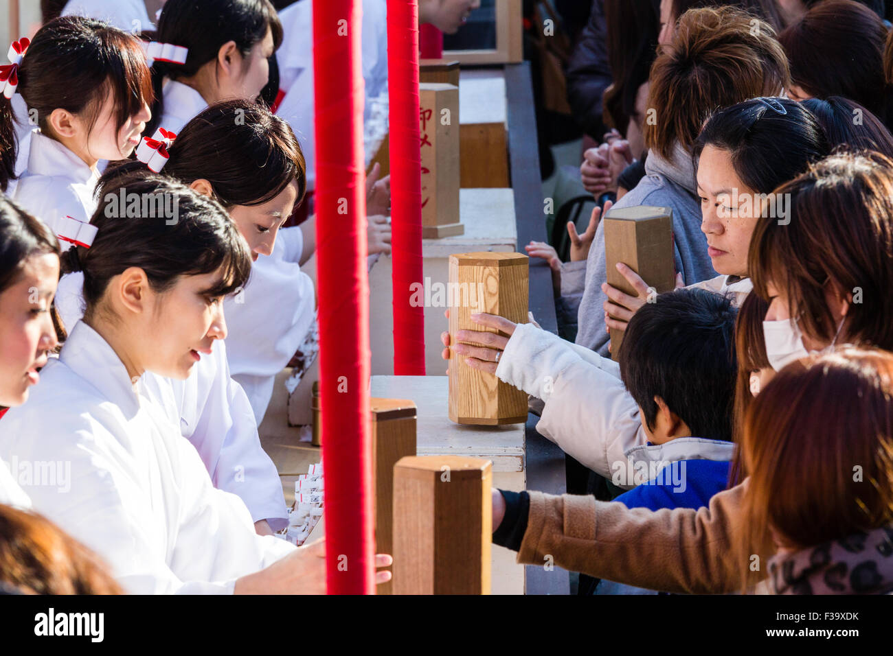 Ikuta shrine, Kobe. New Year. Crowds filling the shrine buying fortune papers, omikuji, from ...