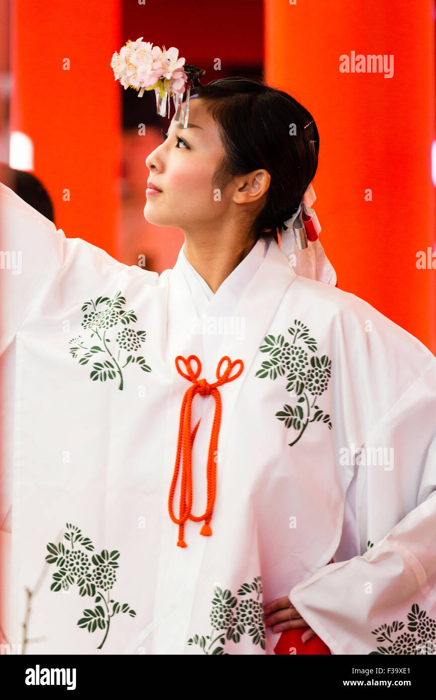 Japan, Ikuta shrine, Kobe. Miko, shrine maiden, performing ritual dance ...