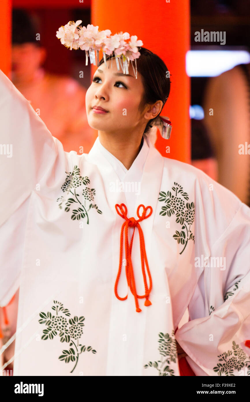 Japan, Ikuta shrine, Kobe. Miko, shrine maiden, performing ritual dance called Kagura, with ...