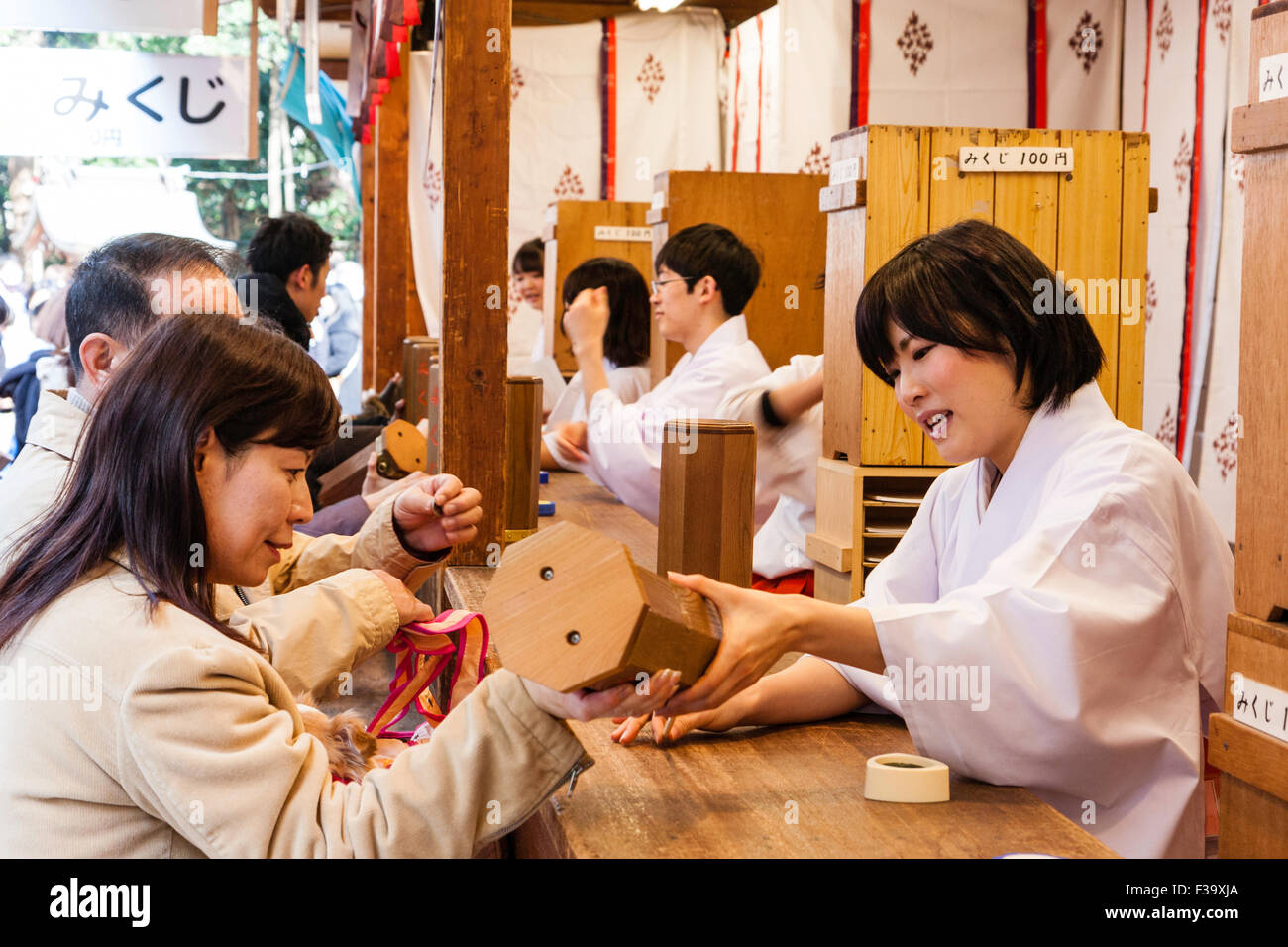 Japan, Nishinomiya shrine, New year Day, Shogatsu. Woman buying omikuji ...