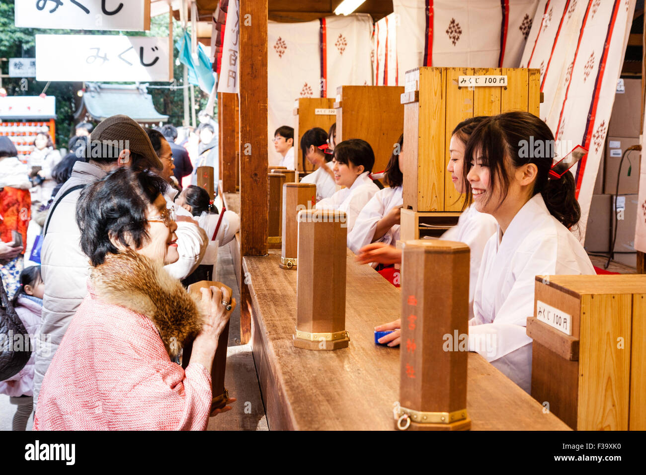 Japan, Nishinomiya shrine, New year Day, Shogatsu. Woman buying omikuji ...