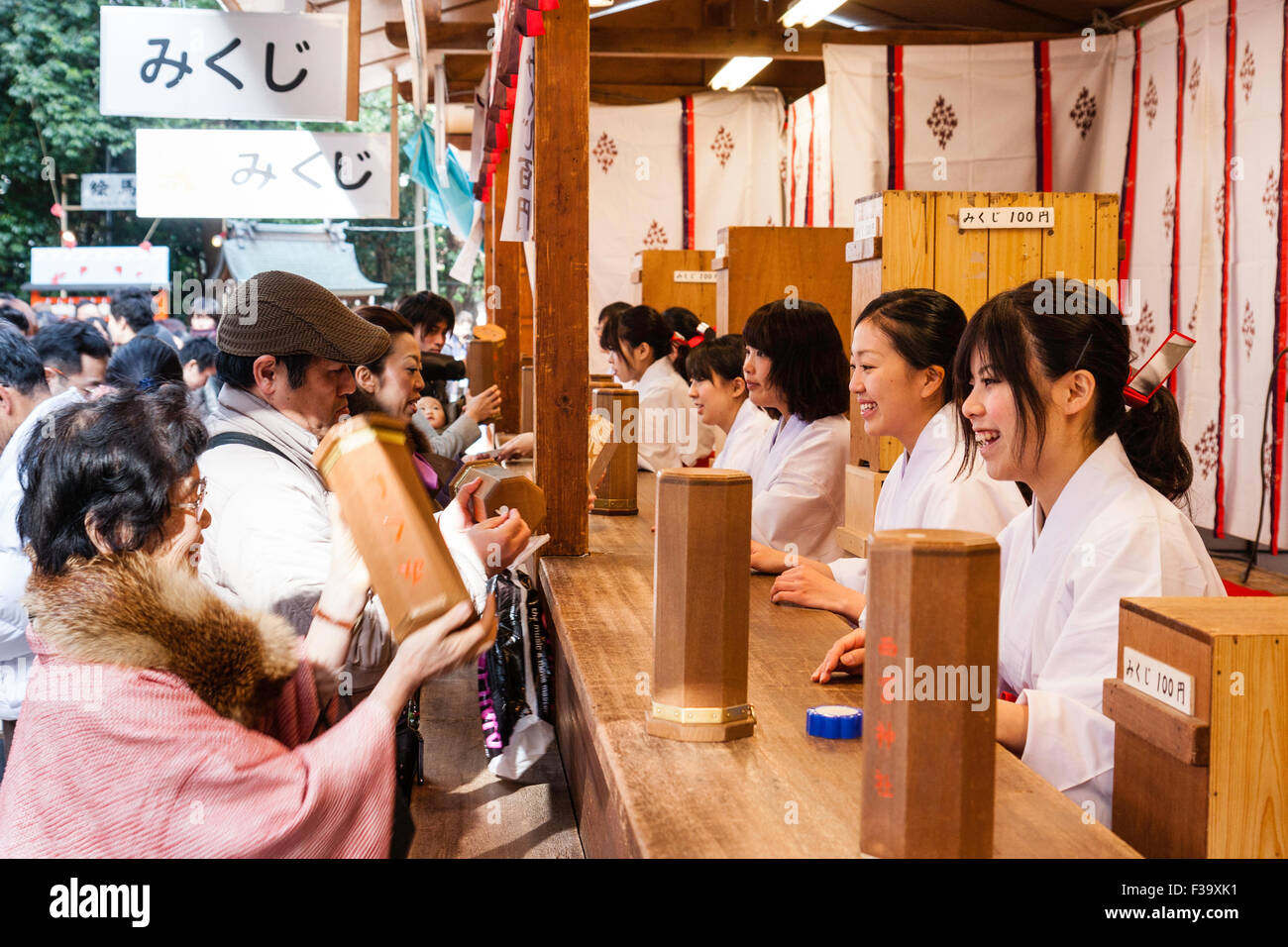 Japan, Nishinomiya shrine, New year Day, Shogatsu. Woman buying omikuji ...