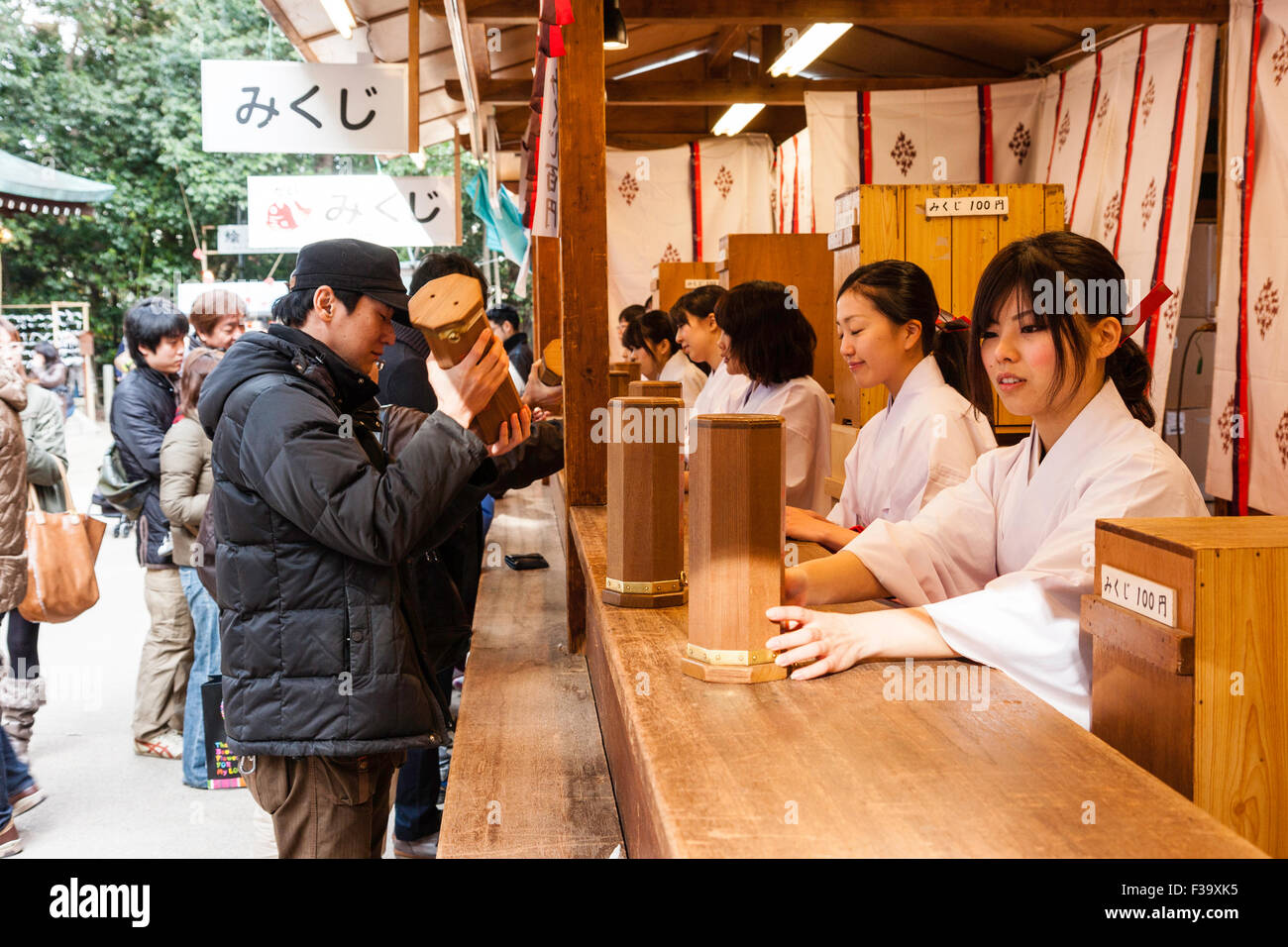 Japan, Nishinomiya shrine, New year Day, Shogatsu. Woman buying omikuji ...