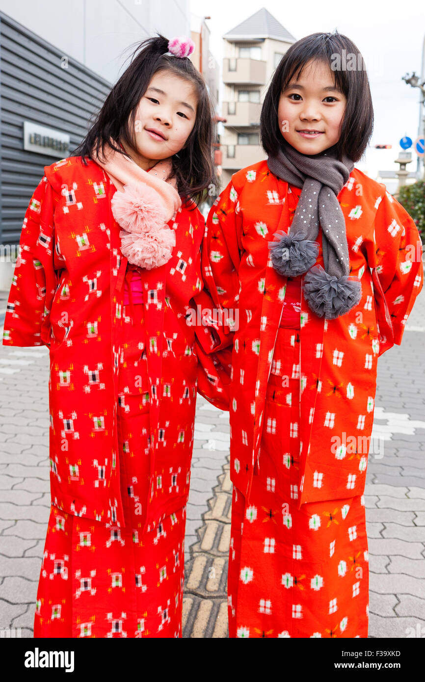 Two young children, Japanese girls, 6 to 8 year old, standing posing ...