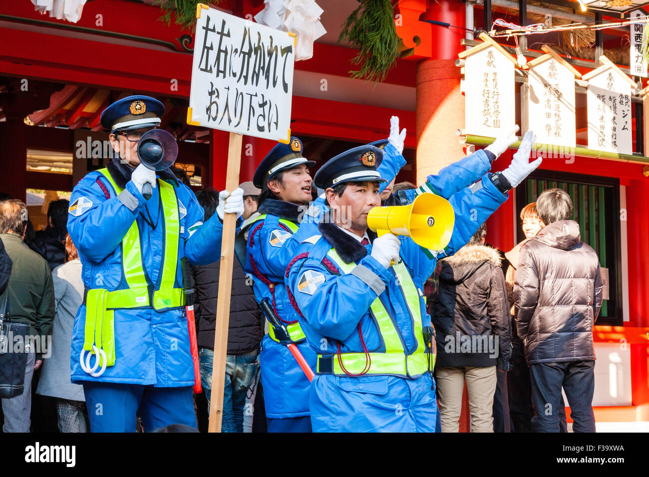 Japanese security men in blue jackets standing in Shinto shrine trying ...
