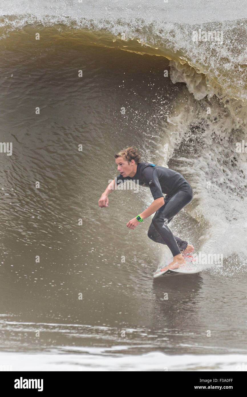 A surfer rides a wave at the Folly Washout as Hurricane Joaquin passes ...