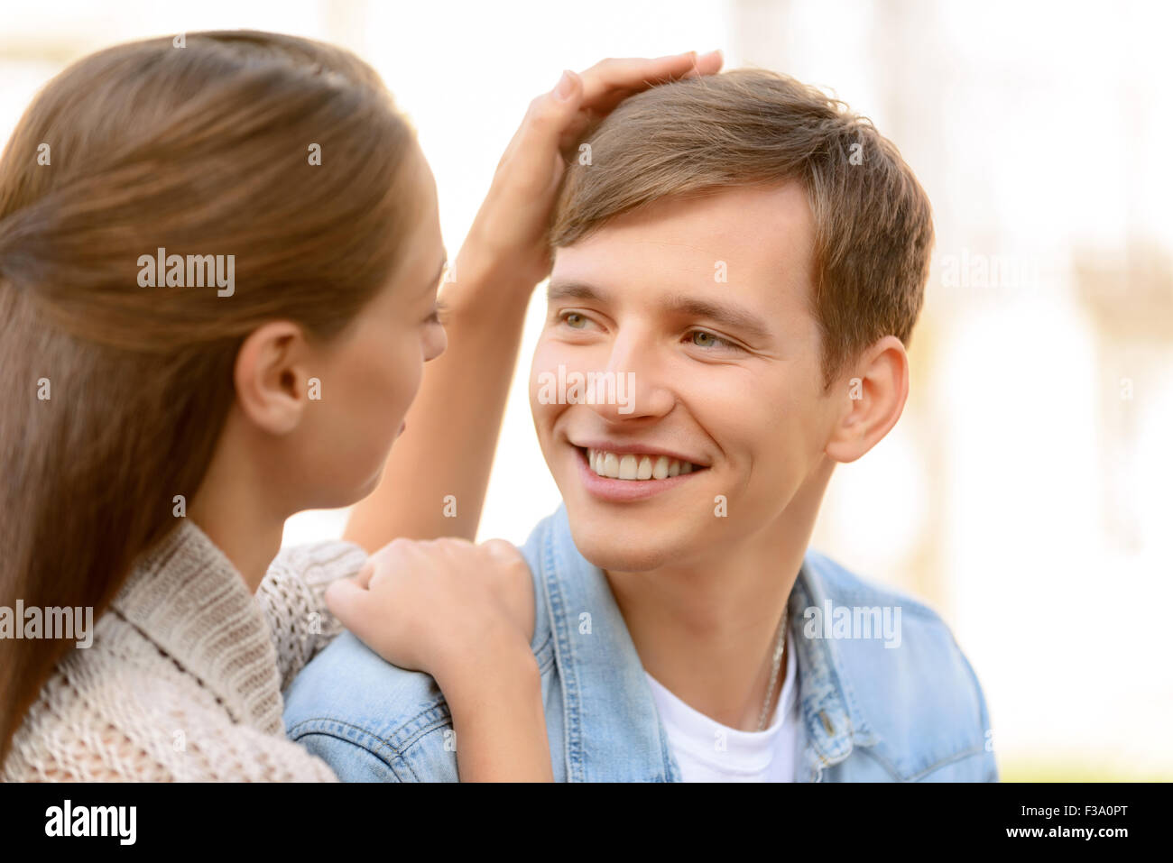 Together forever. Happy contented young couple smiling and bonding to ...