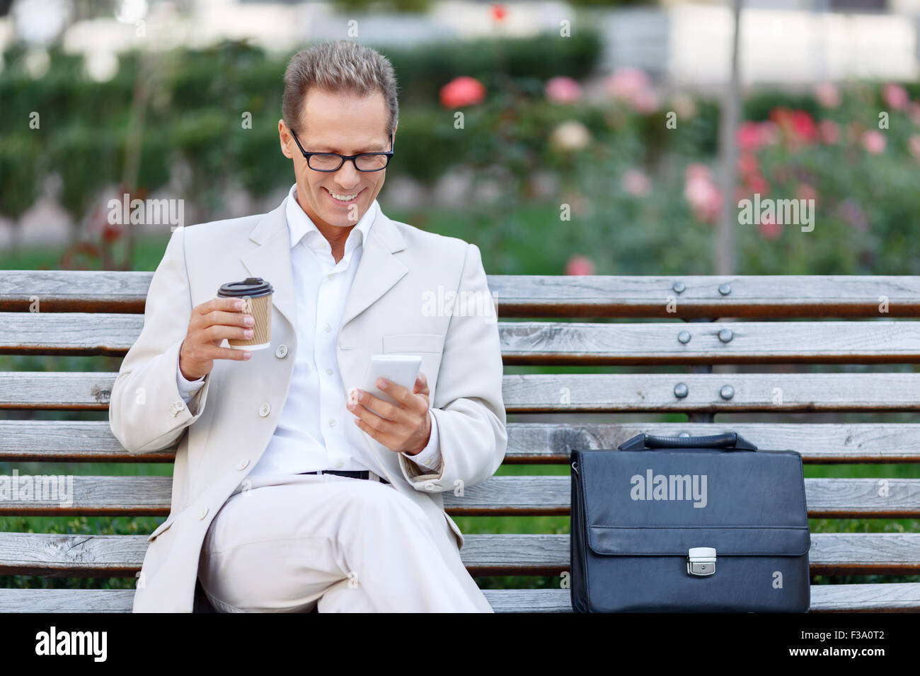 Good news. Cheerful handsome vivacious man holding mobile phone an ...