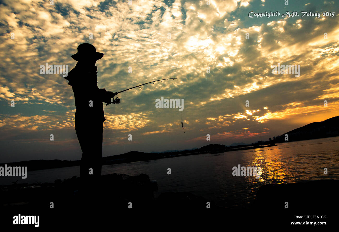Fishing alone man Gloomy evening Stock Photo - Alamy