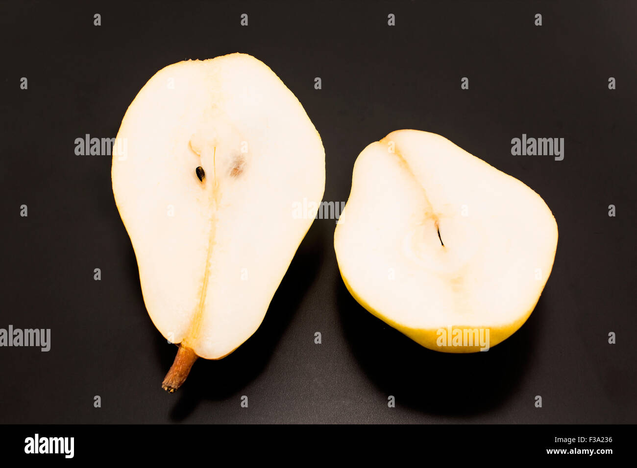 Two halves of a pear isolated on black Stock Photo - Alamy