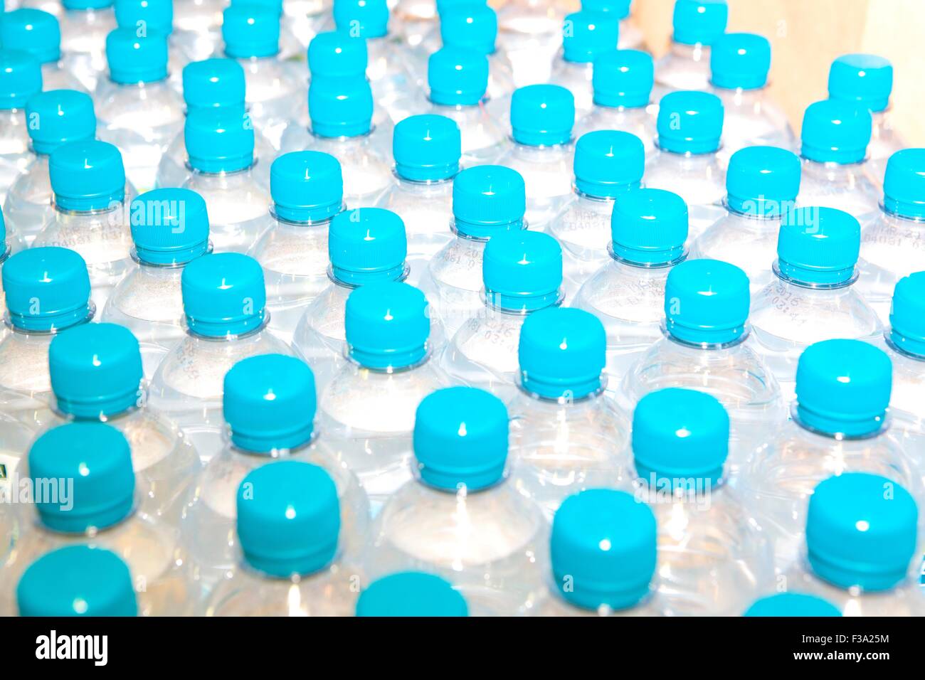 clear plastic water bottles with bright blue lids Stock Photo - Alamy