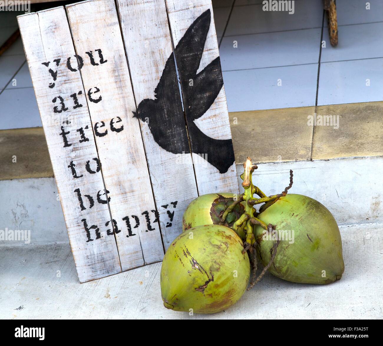 "You are free to be happy" sign with a bunch of green young coconuts ...
